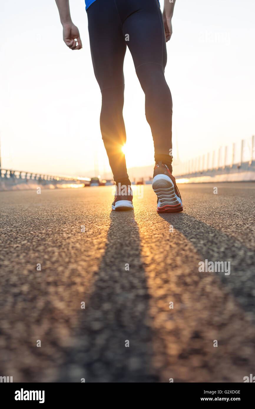 feet of an athlete running on a park pathway training for fitness and ...