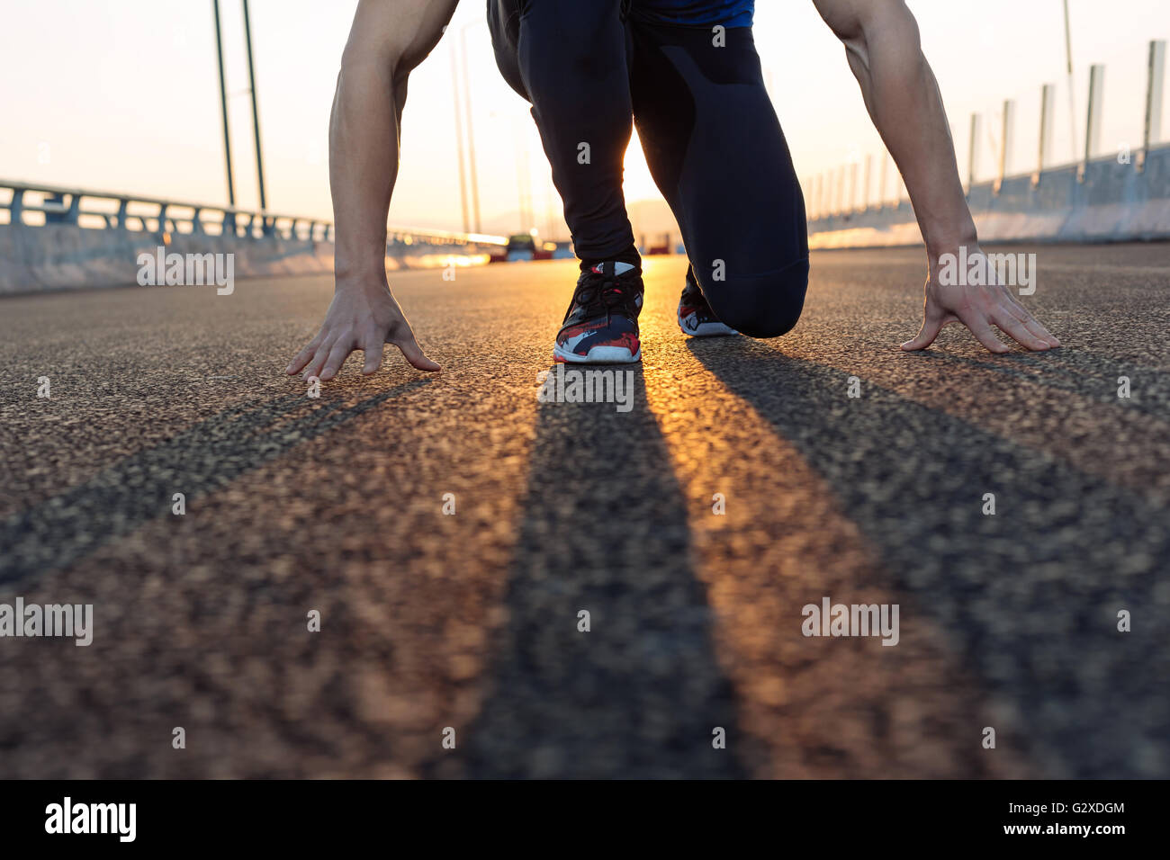 Athletic man starting evening jogging in sun rays, close up of hands ...