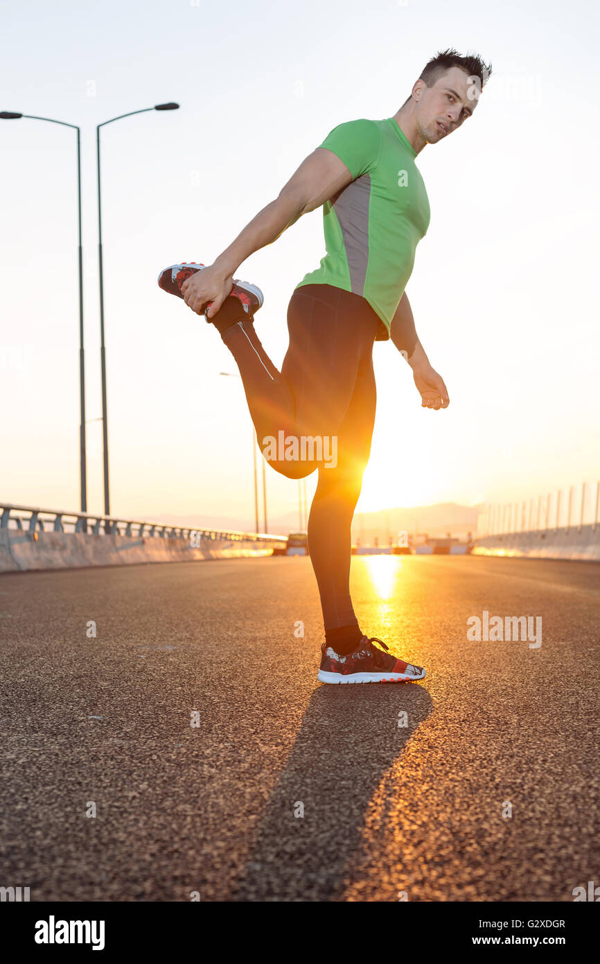 Stretching after jogging. sunset shot on highway Stock Photo - Alamy