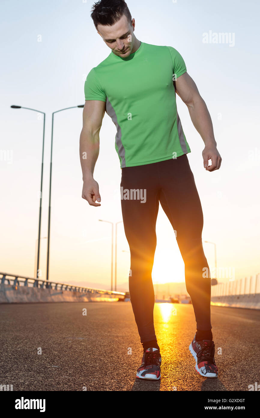 Stretching after jogging. sunset shot on highway Stock Photo - Alamy