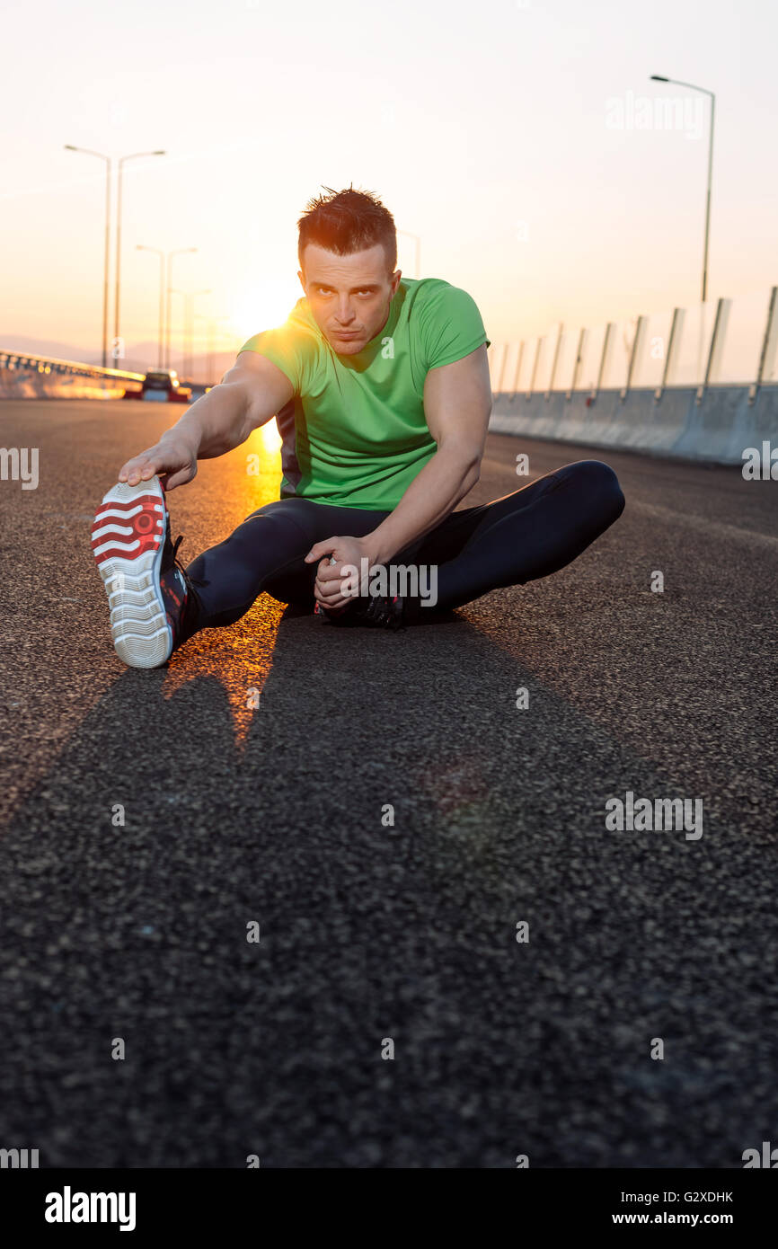 Stretching after jogging. sunset shot on highway Stock Photo - Alamy