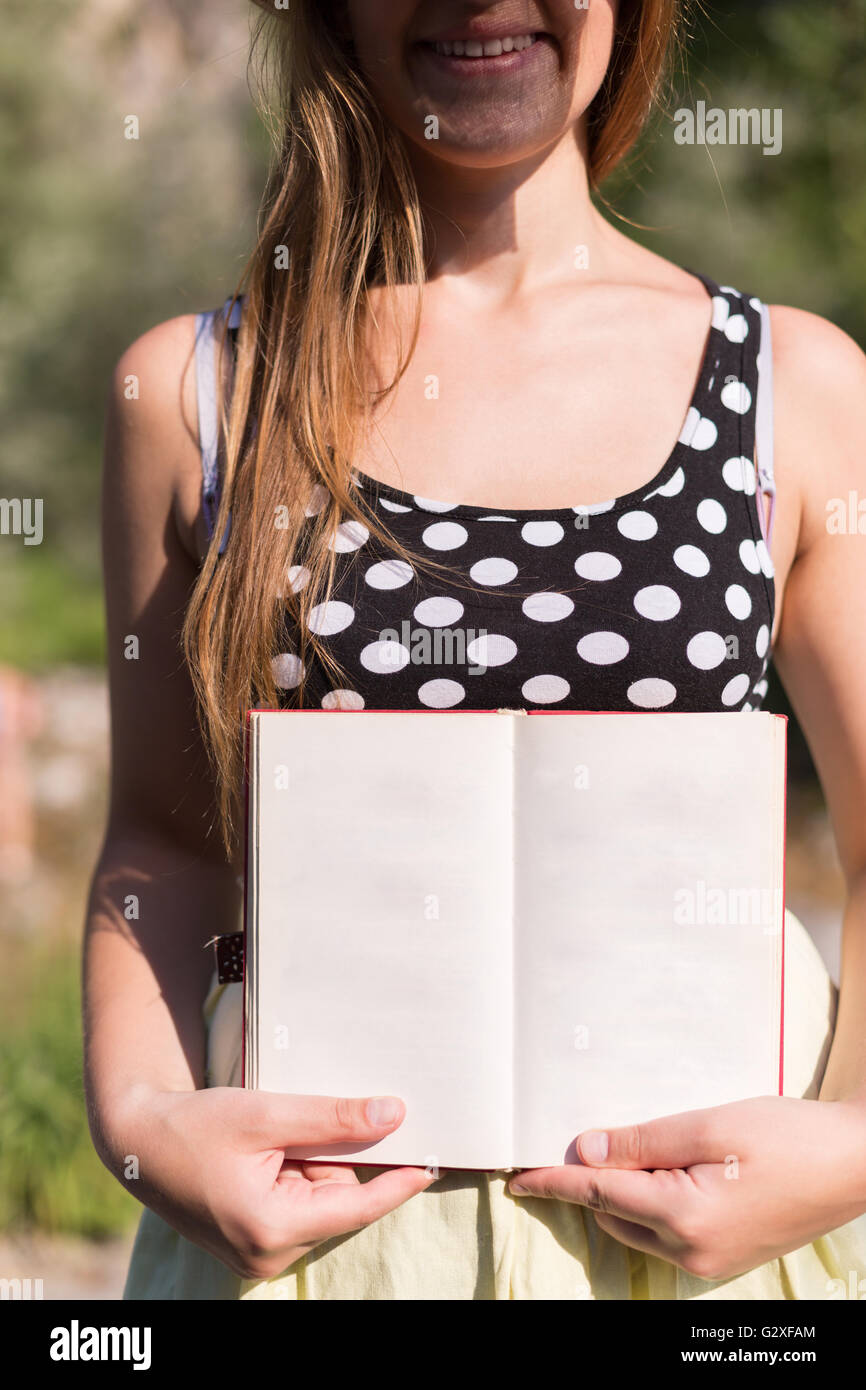 woman holding open book in nature Stock Photo - Alamy