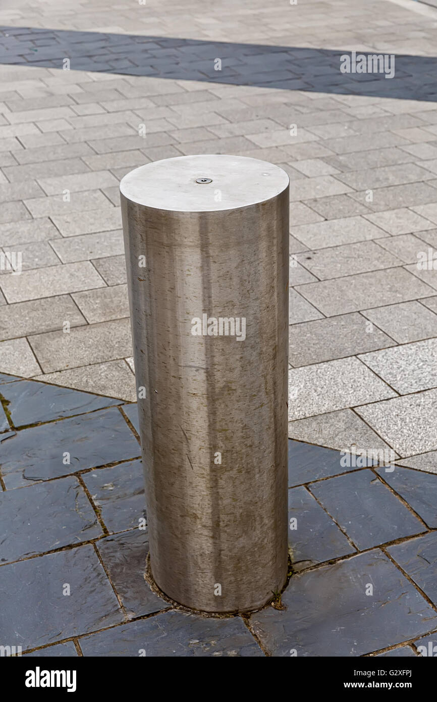 Stainless Steel bollard on grey pavement with a few lines of dark grey paving slabs Stock Photo ...