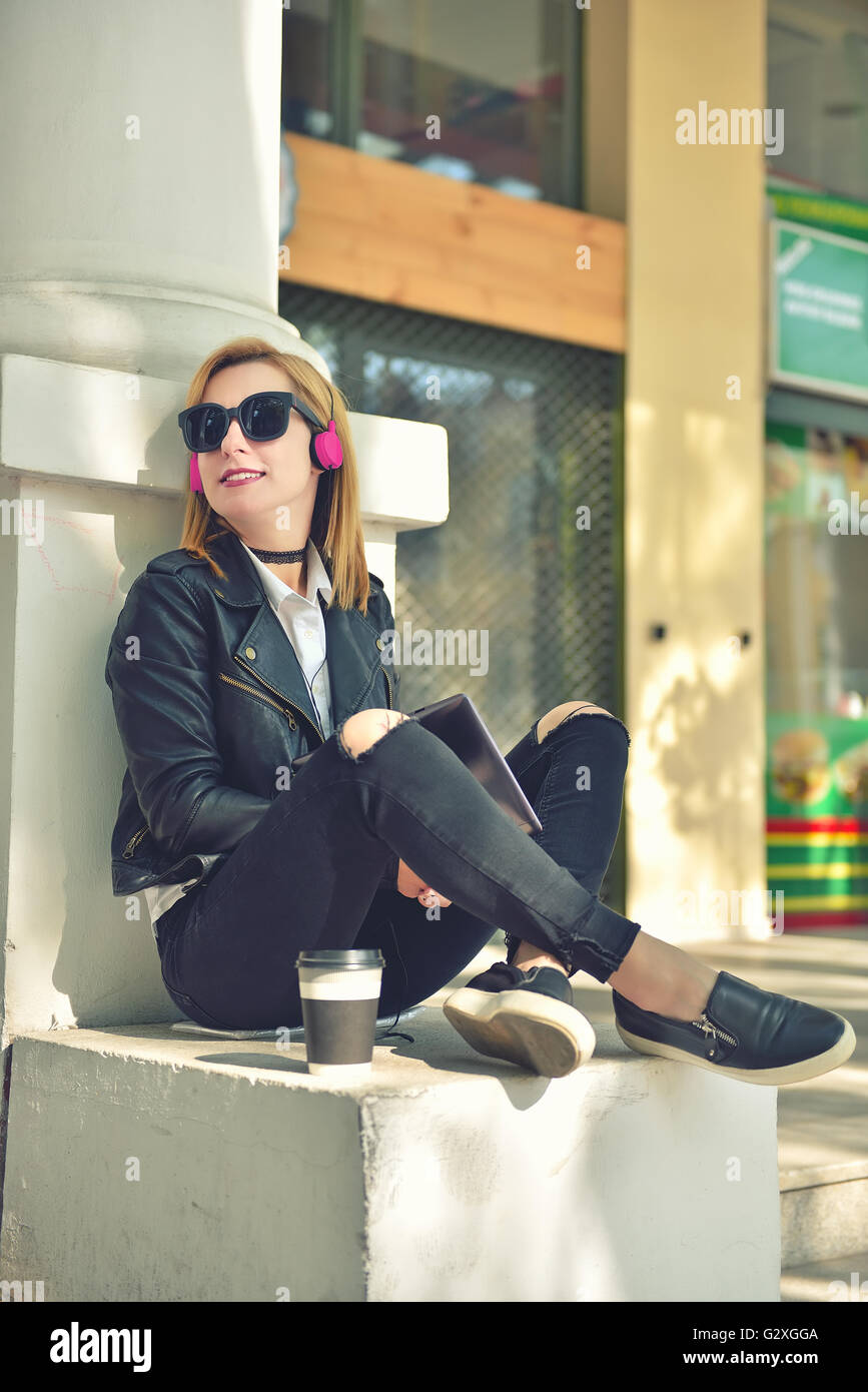 girl sitting with touch pad and listening to music, side view Stock ...