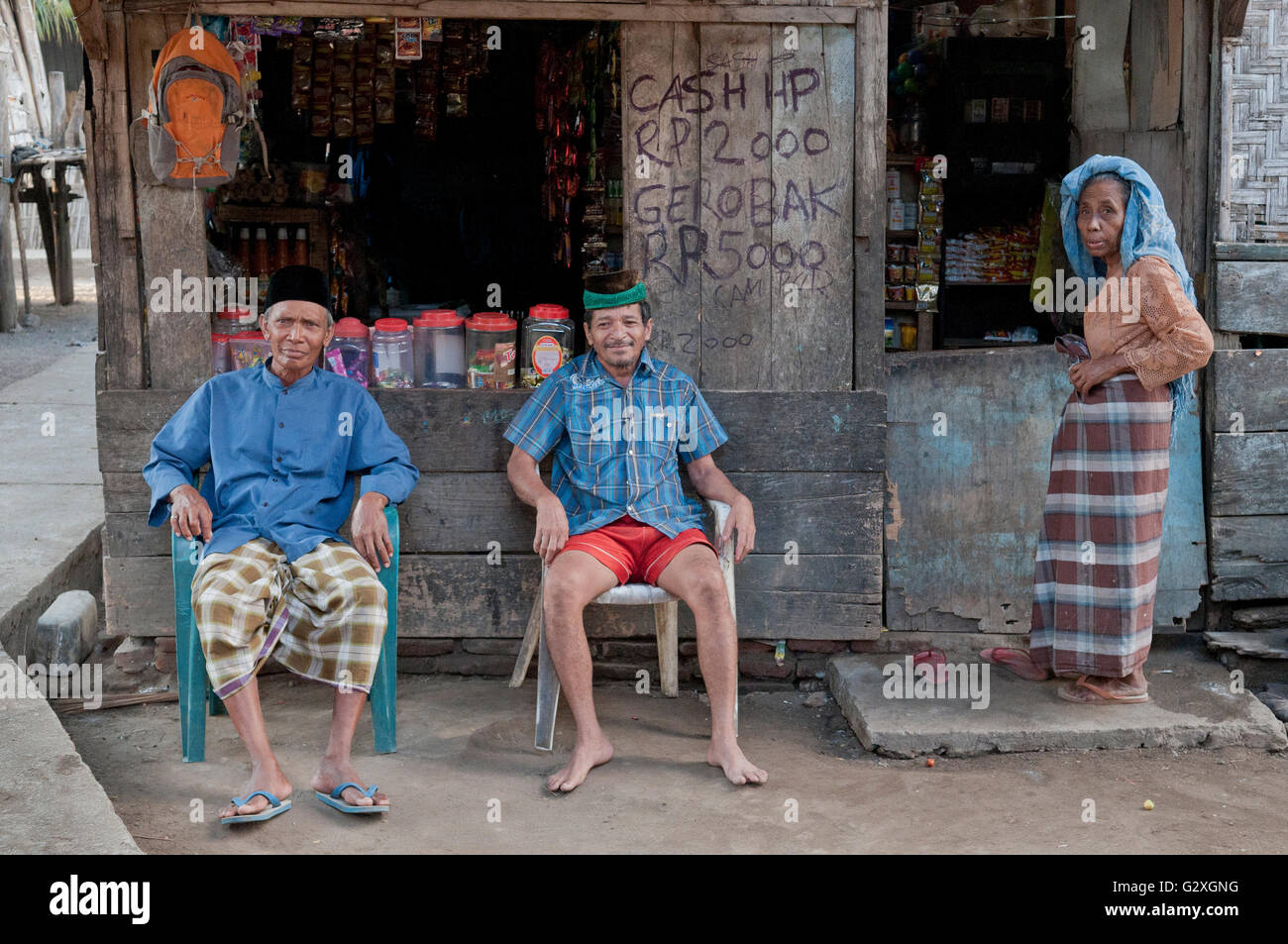 Komodo Island, Fishing Village, two villager men sitting outside shop ...