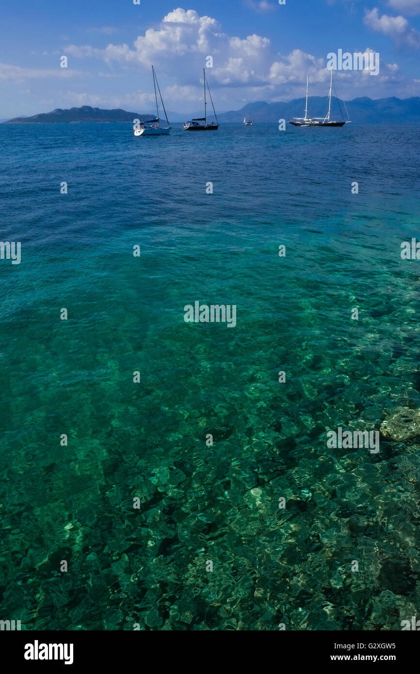 Transparent Greek Sea with boats amd island views Stock Photo - Alamy