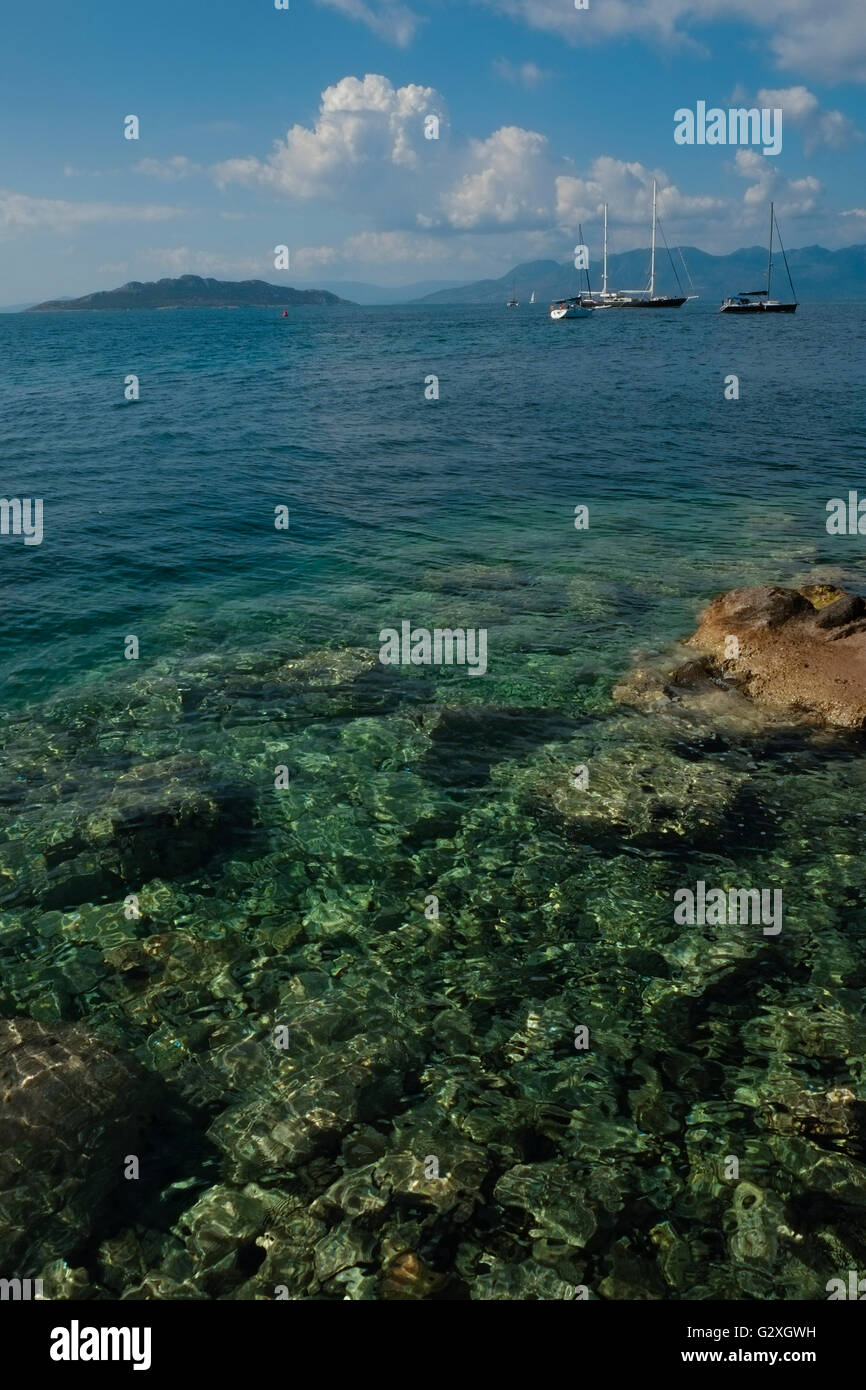 Transparent Greek Sea with boats amd island views Stock Photo - Alamy