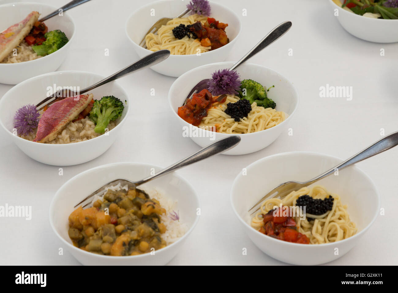 A photograph of some pasta, risotto and rice in white bowls, being ...