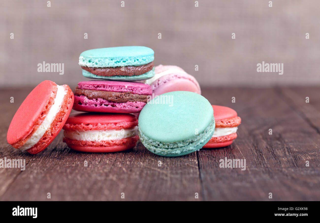 A lot of french colorful macarons on a wood background Stock Photo - Alamy