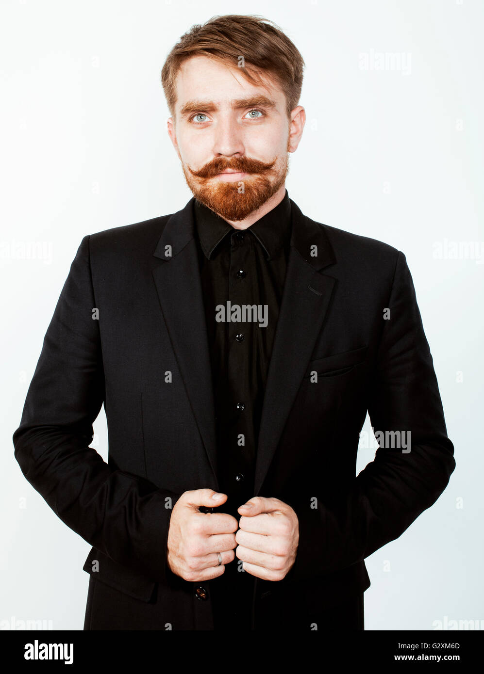 young red hair man with beard and mustache in black suit on white ...