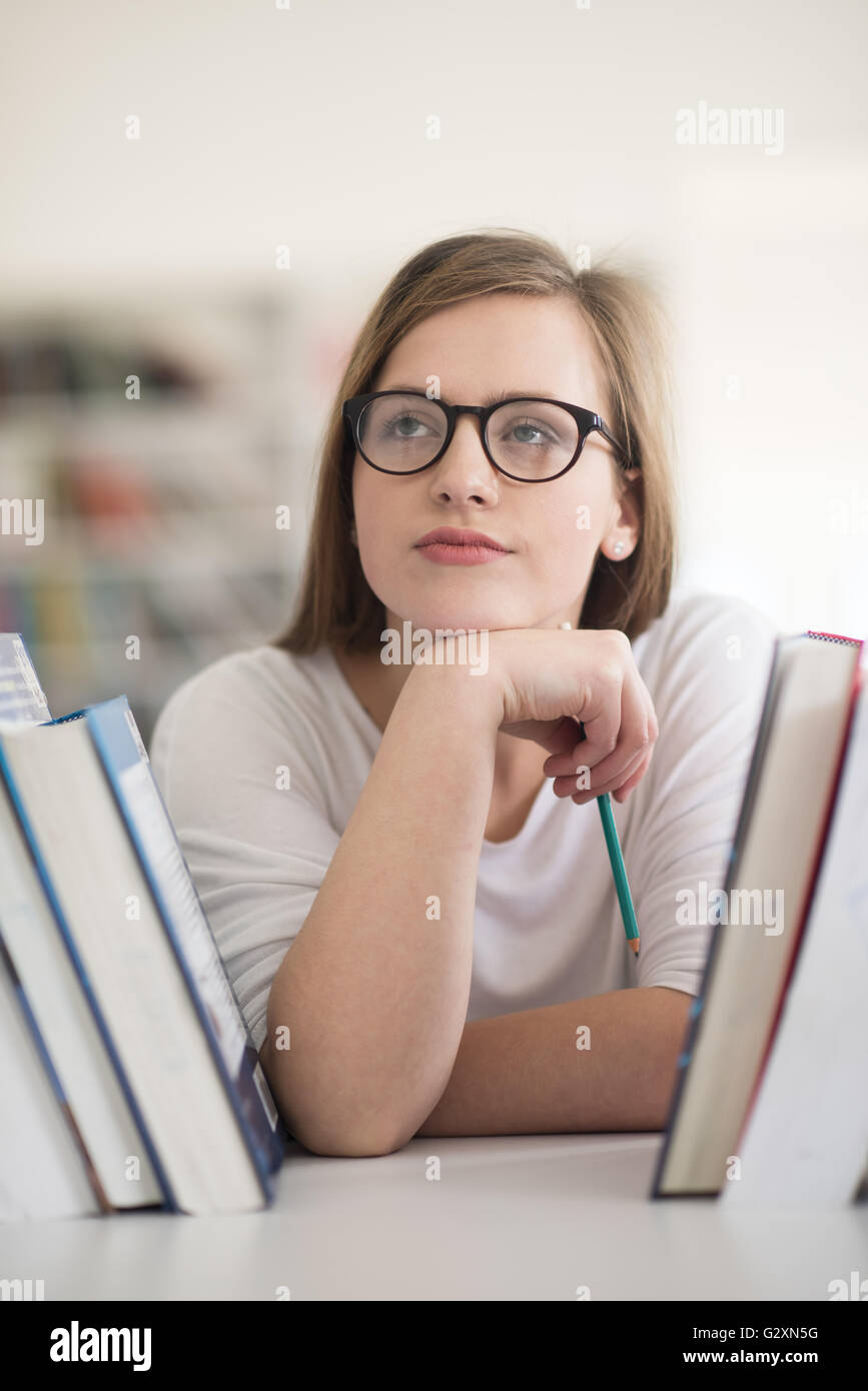 portrait of smart looking famale student girl in collage school library ...