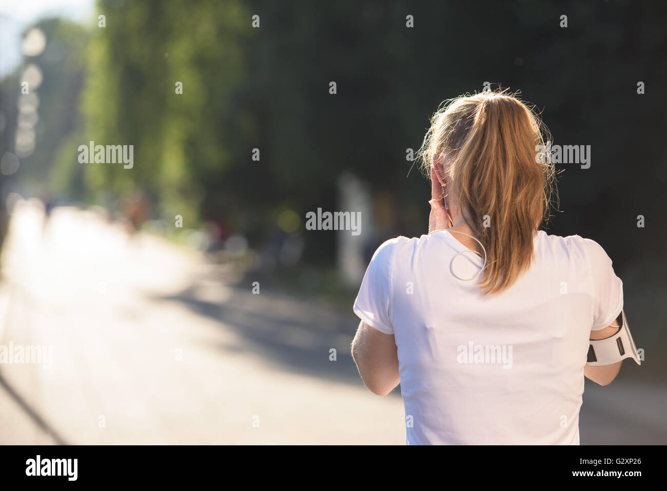 jogging woman setting music and running route on smart phone putting ...