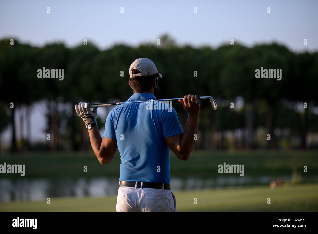 golfer from back looking to ball and hole in distance, handsome middle ...