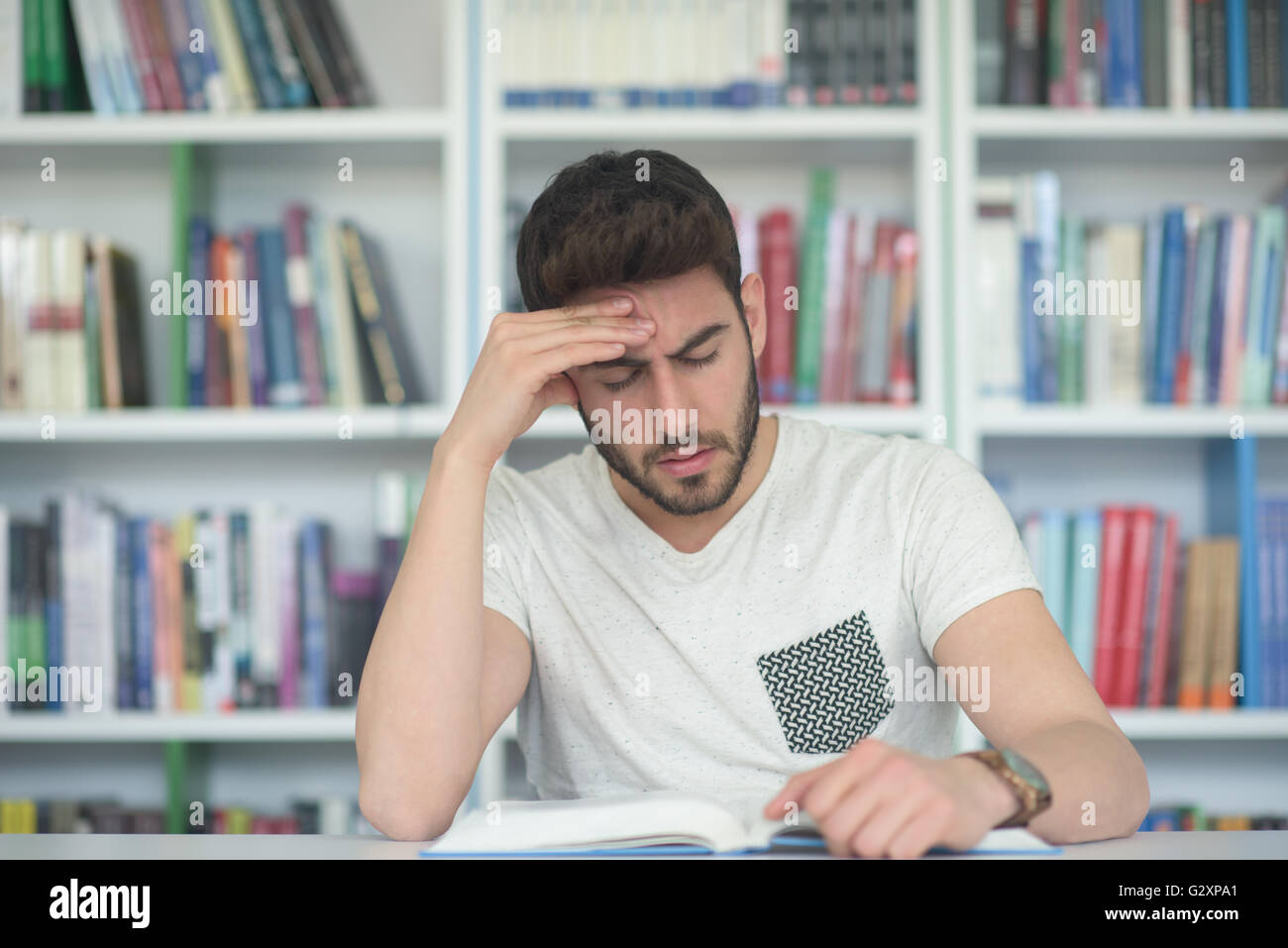 Student reading book in school library. Study lessons for exam. Hard ...