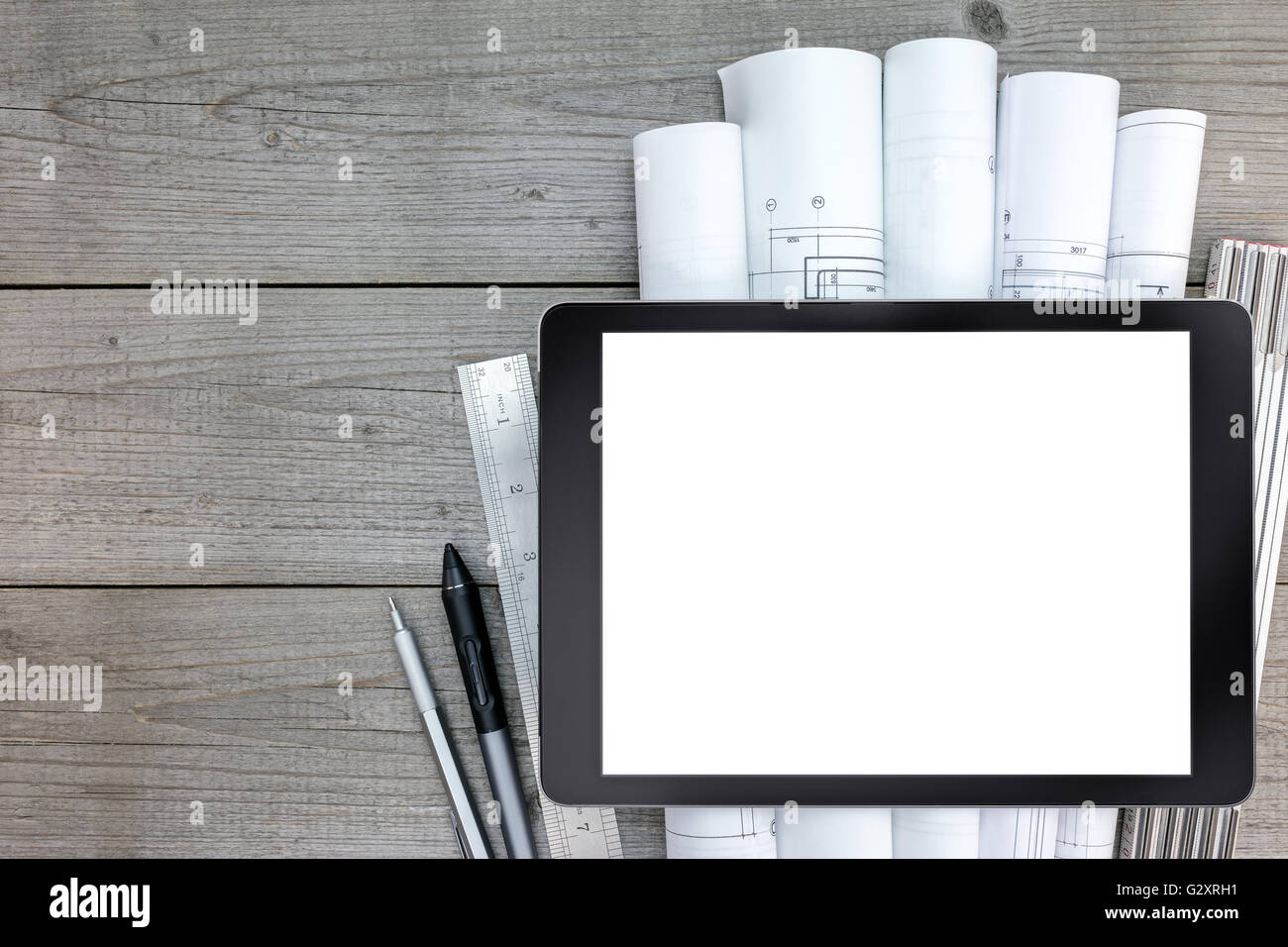 tablet with architectural blueprints and measuring tools on wooden ...