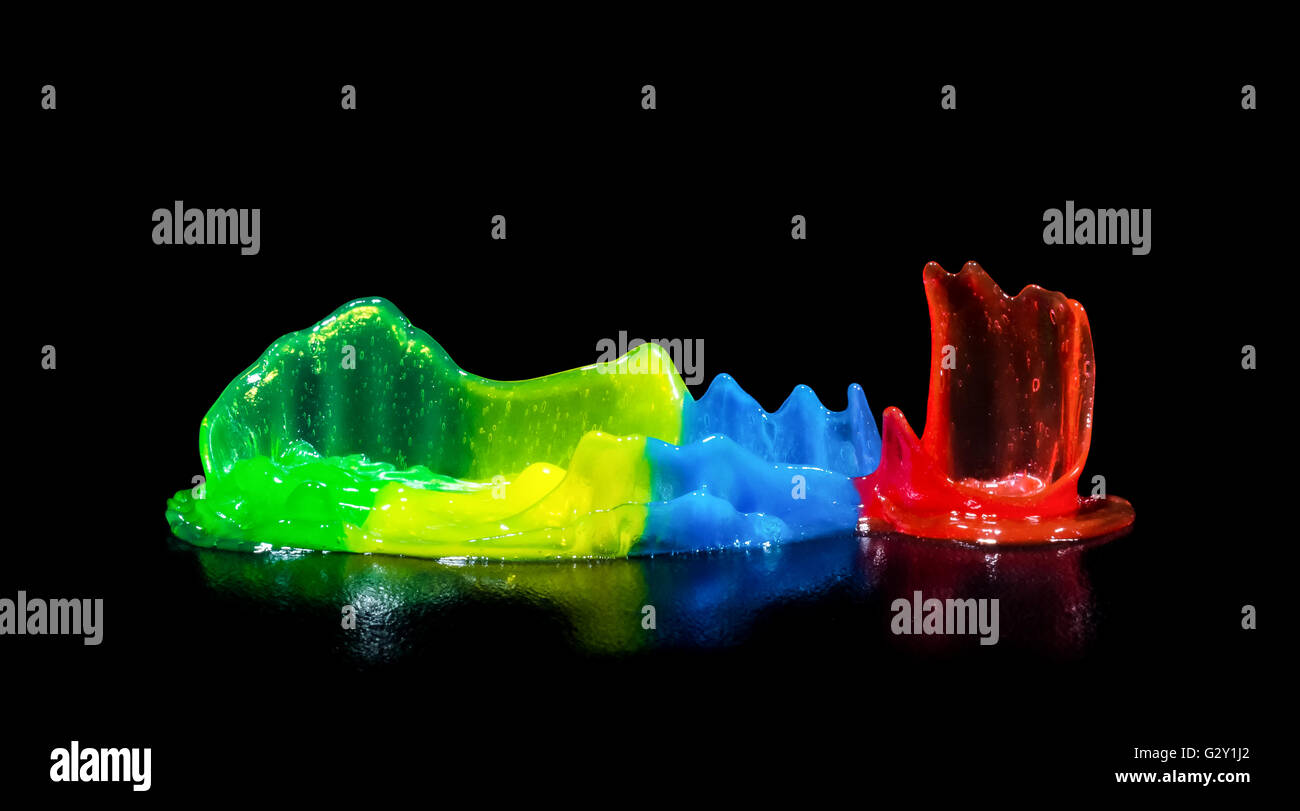 Colorful paint splashing or slime on an audio speaker isolated on black ...
