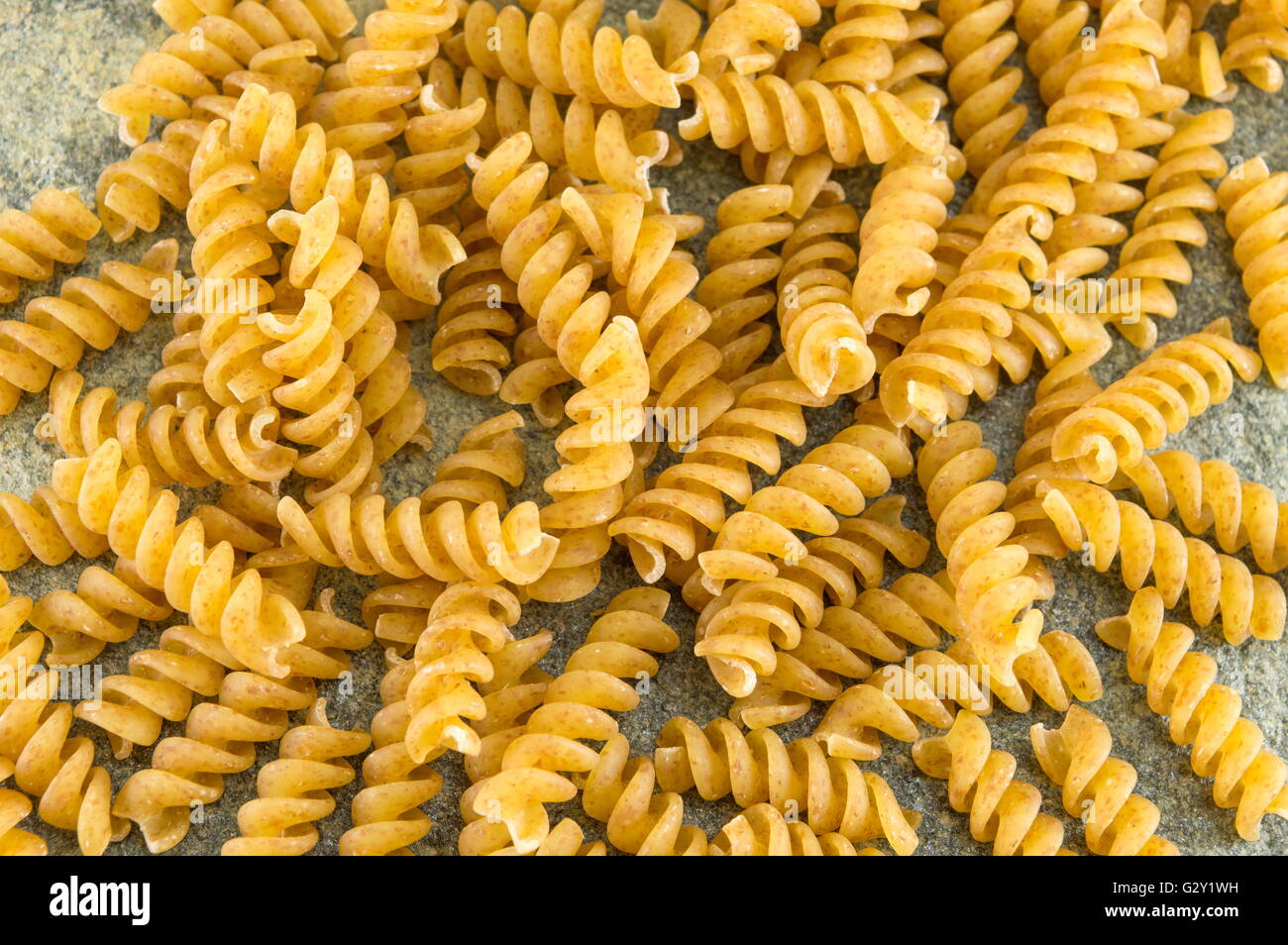 Bunch of golden colored macaroni pasta on a table Stock Photo - Alamy