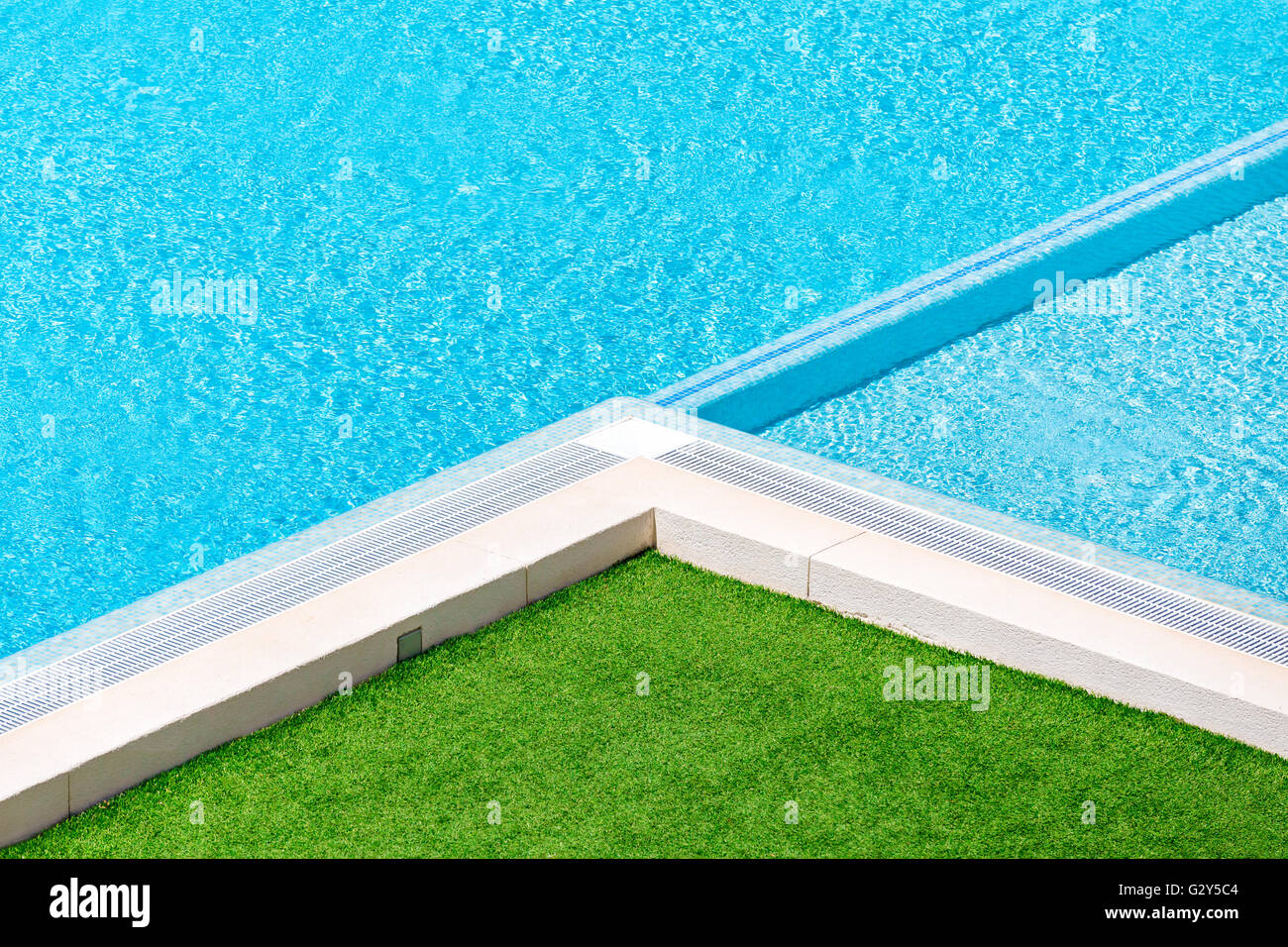 Corner of swimming pool with green grass around Stock Photo - Alamy