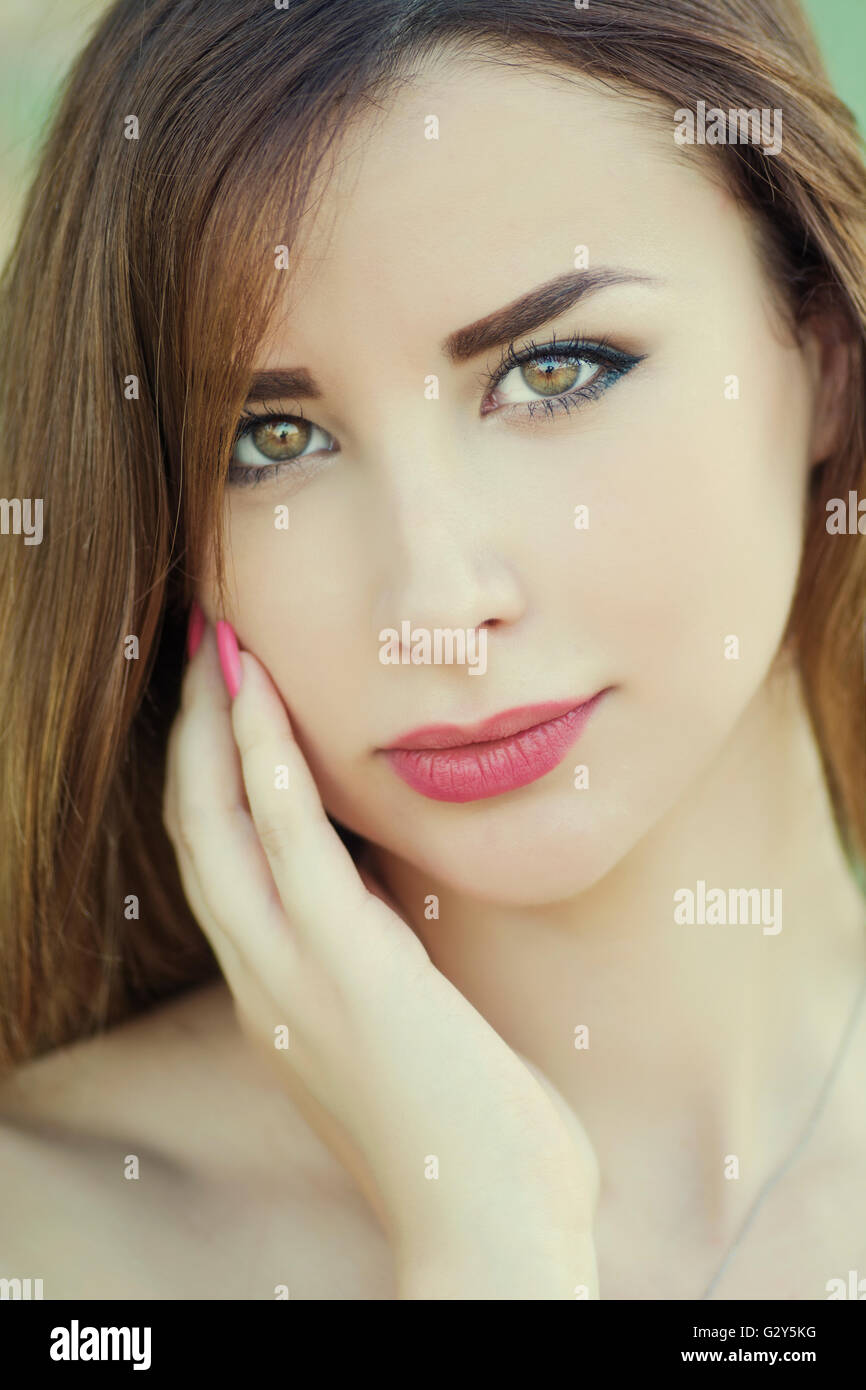 Beautiful young woman hand touching face outdoors Stock Photo - Alamy