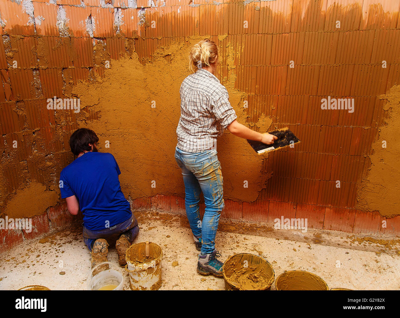applying natural clay plasters on a wall, natural way without ...