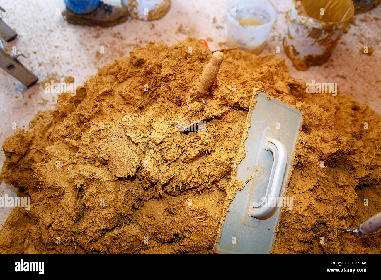 Preparing for the mass natural clay plasters with working tools Stock ...
