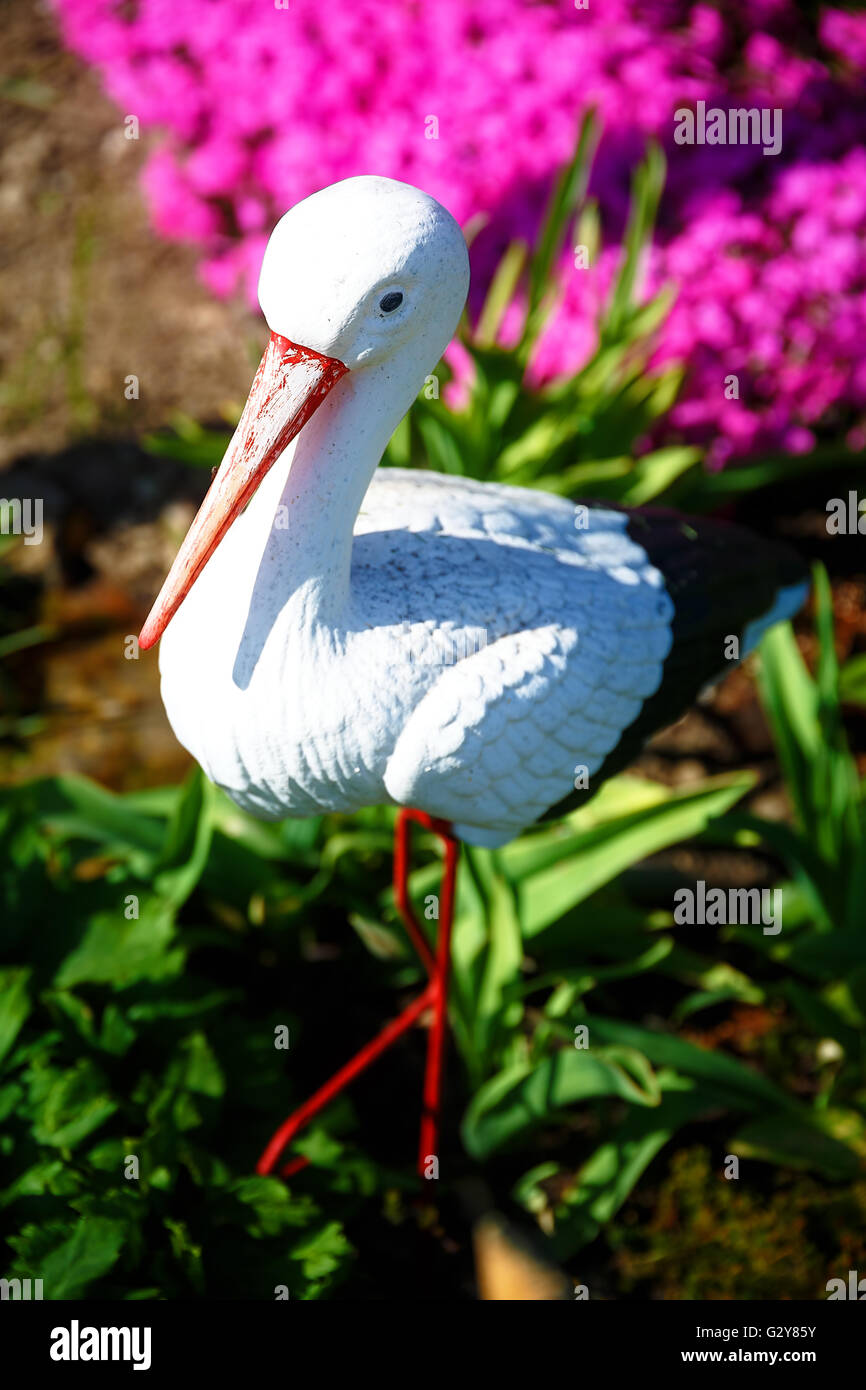 stork sculpture in garden with purple flower Stock Photo - Alamy