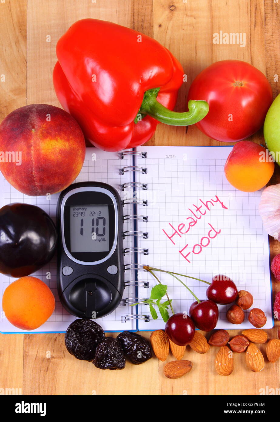 Fresh fruits, vegetables and glucose meter on notebook for writing ...