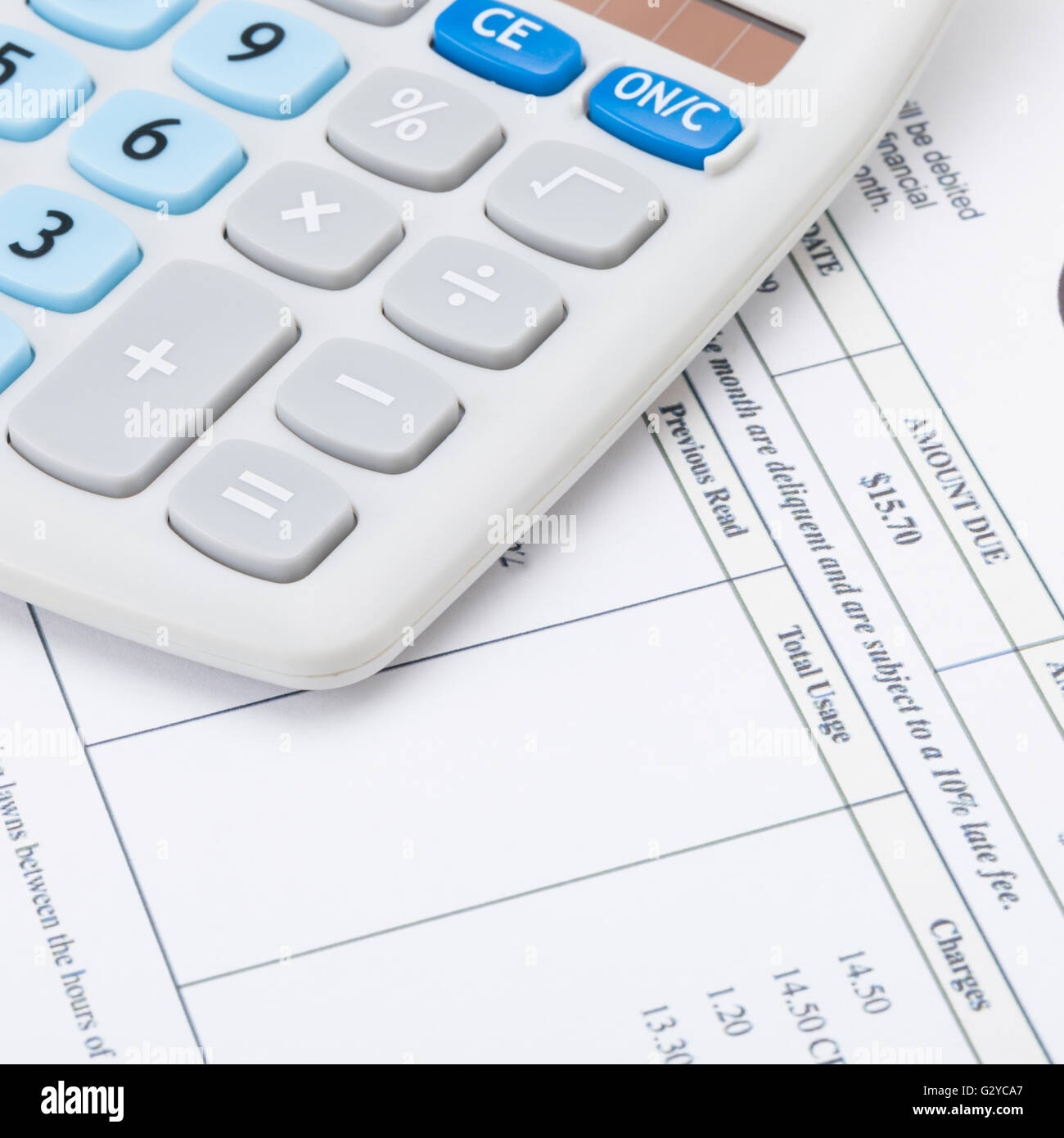 Close up studio shot of a neat calculator with utility bill under it ...