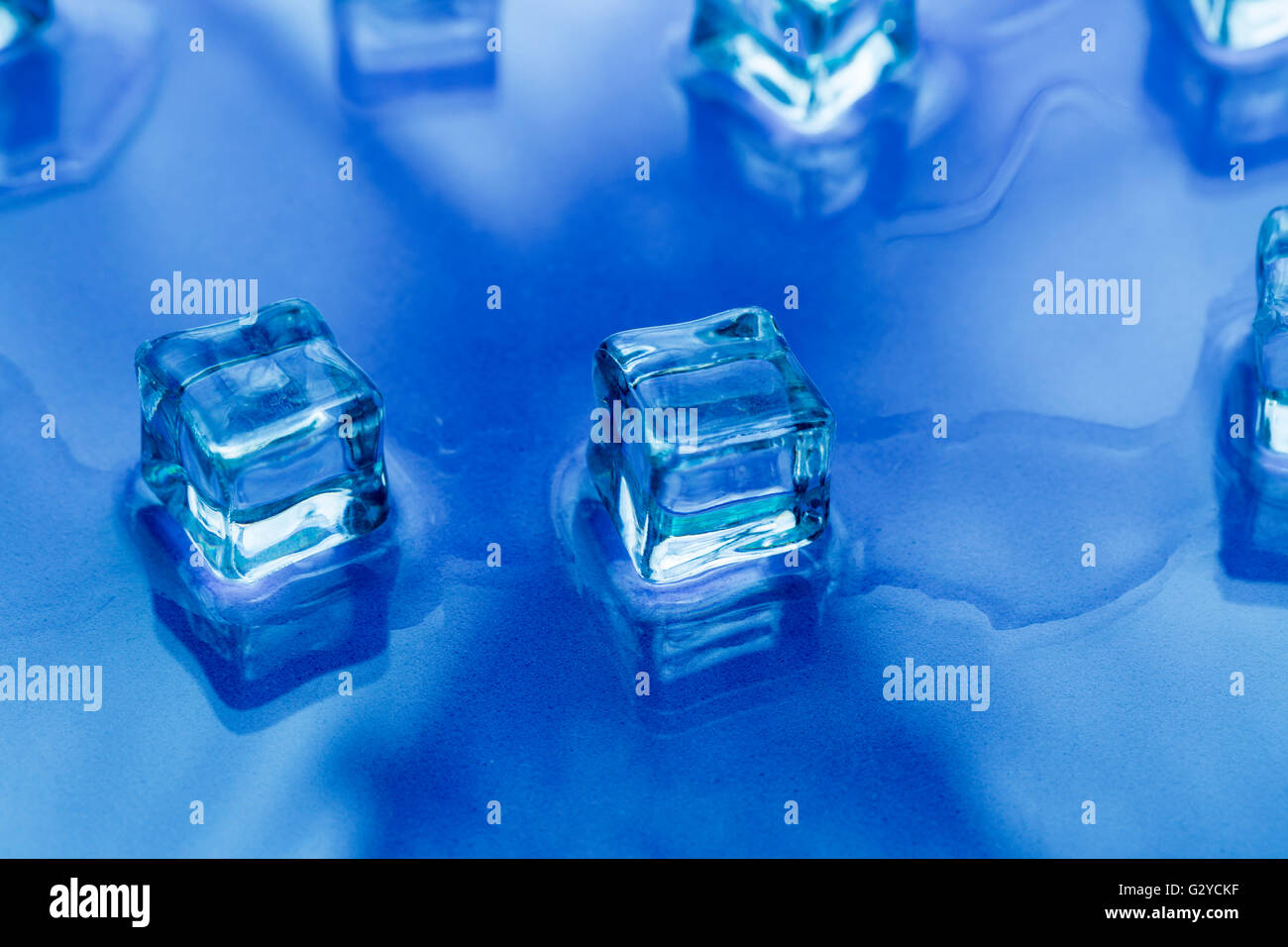 Many blue melting ice cubes on glass Stock Photo - Alamy