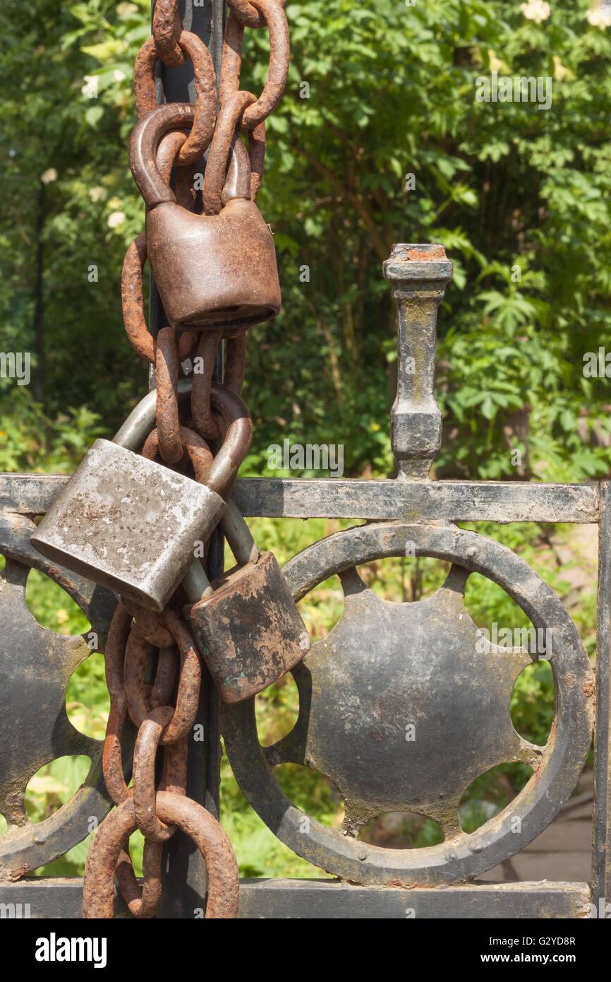 Old rusty lock on a metal gate into the garden. Lock on the iron gate ...