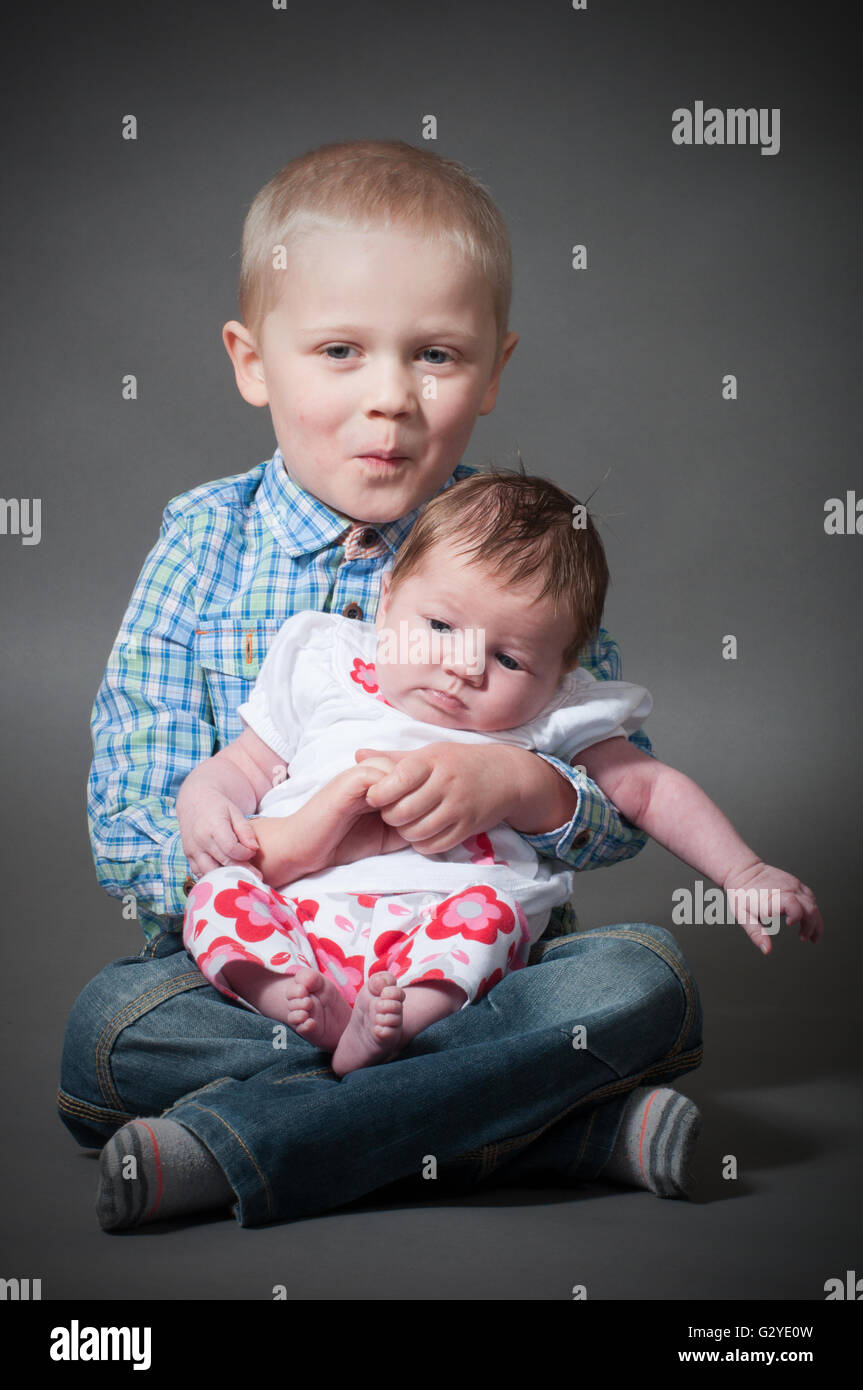 Proud boy holding a new born baby Stock Photo - Alamy
