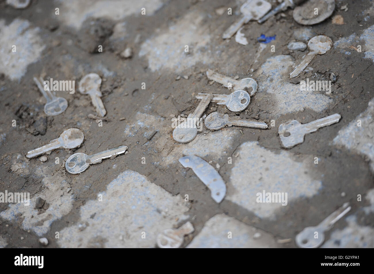Mud-stained keys lie on the ground in front of a locksmith shop in ...