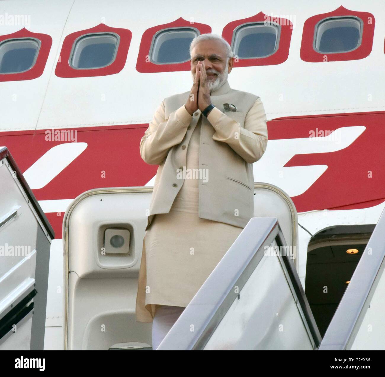 Indian Prime Minister Narendra Modi thanks his hosts as he boards his ...