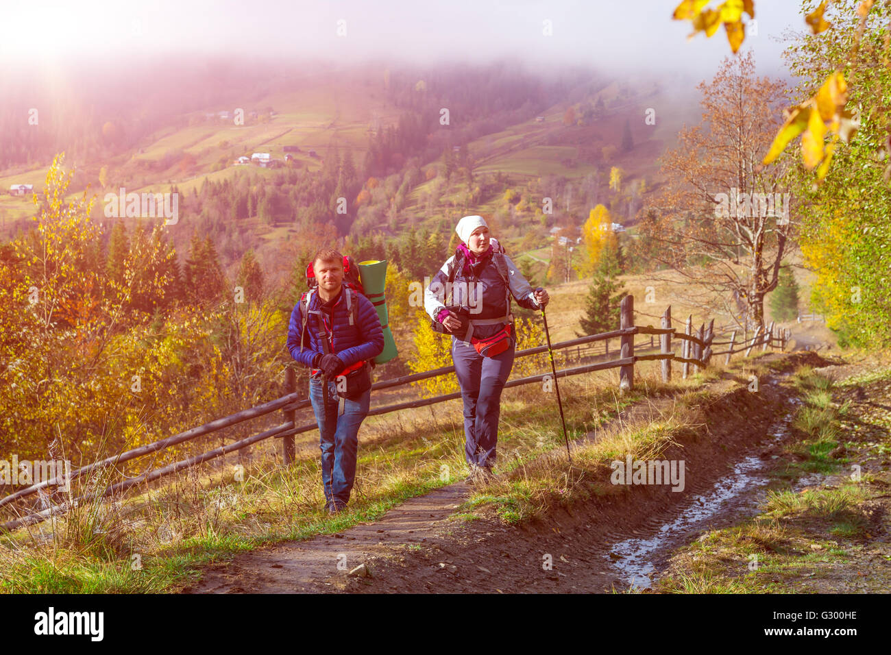 Two Hikers Walking on Rural Trail among Autumnal Forest Stock Photo - Alamy
