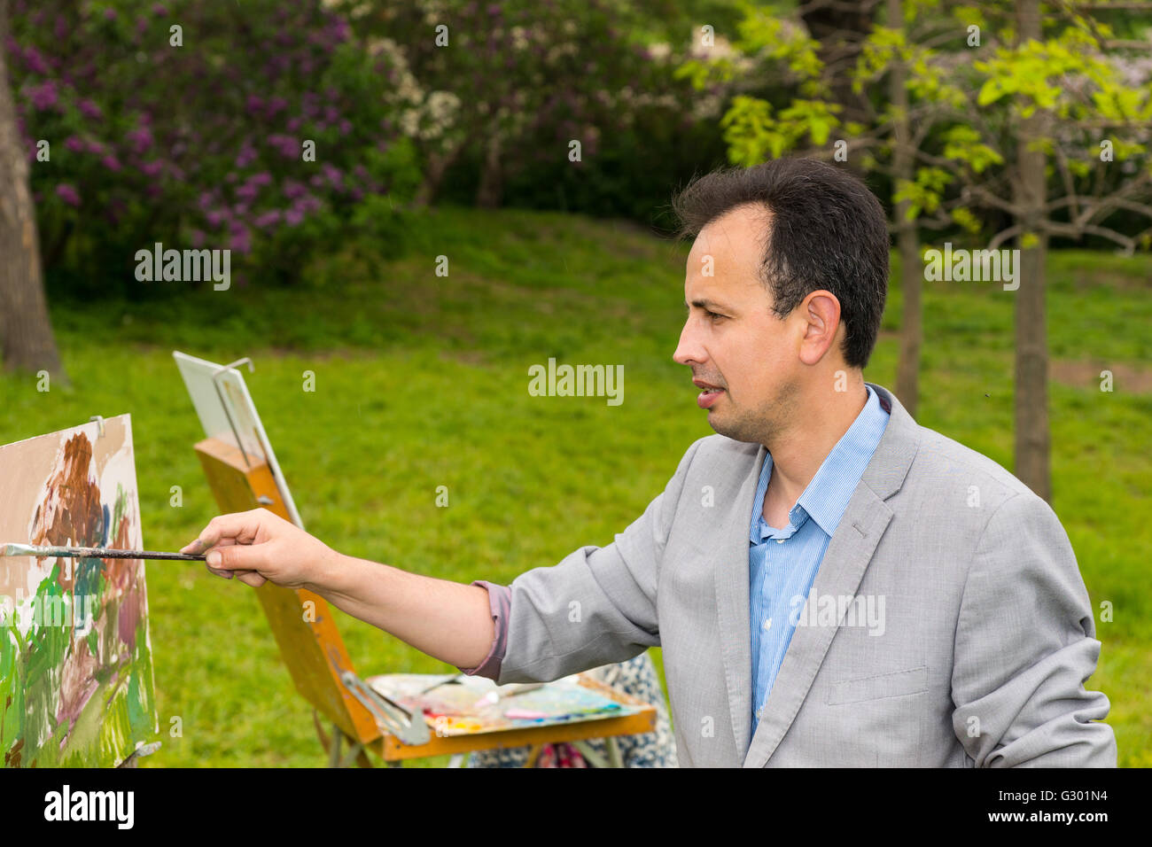 Handsome fashionable male artist during creation a masterpiece on a ...