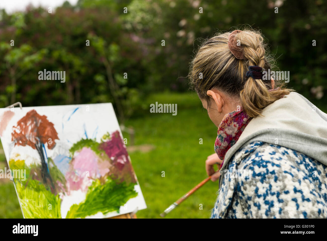 Female undistracted artist painting with oils and acrylics finishing ...