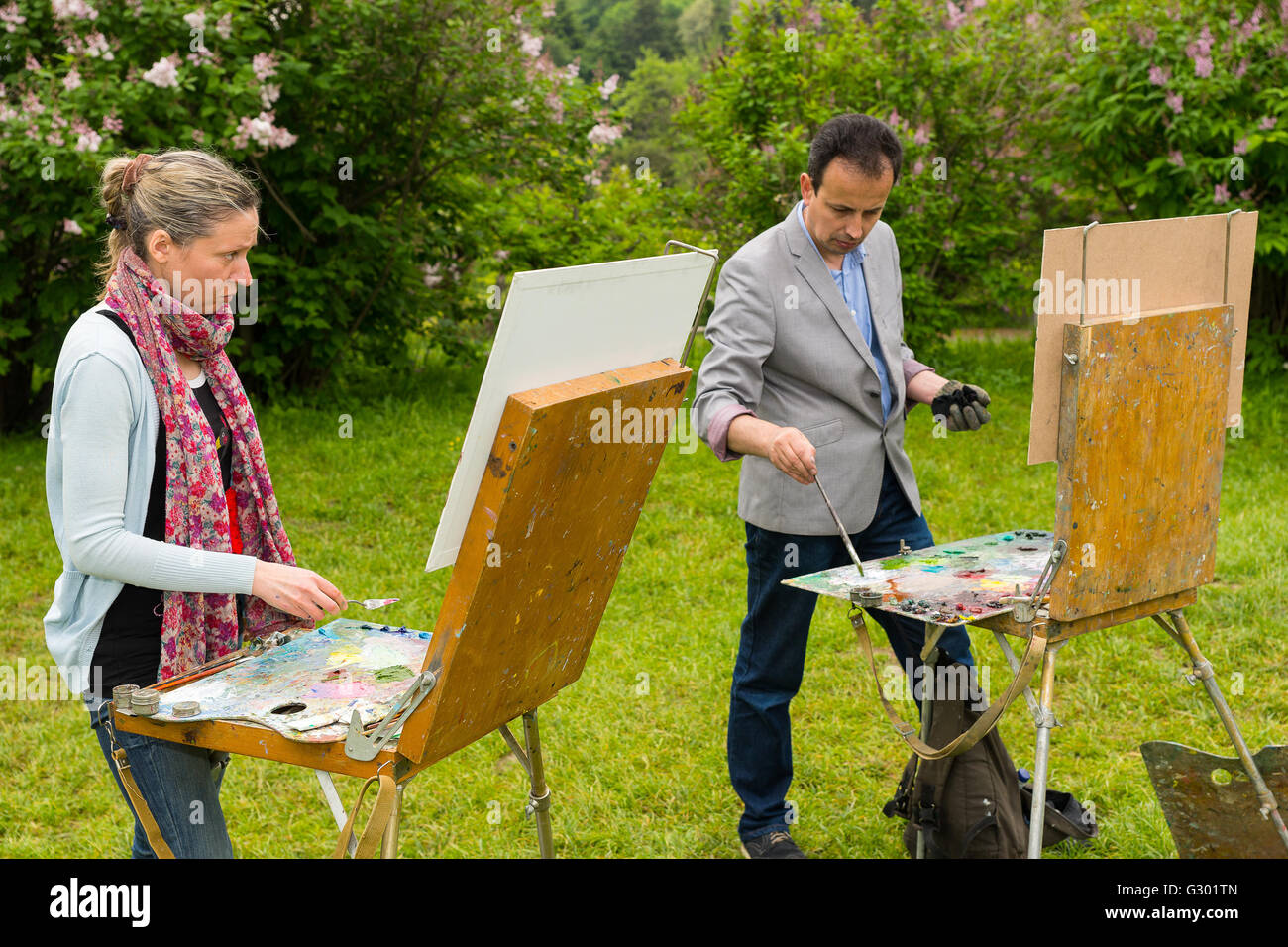 Two professional creative painters working on a trestle and easel ...