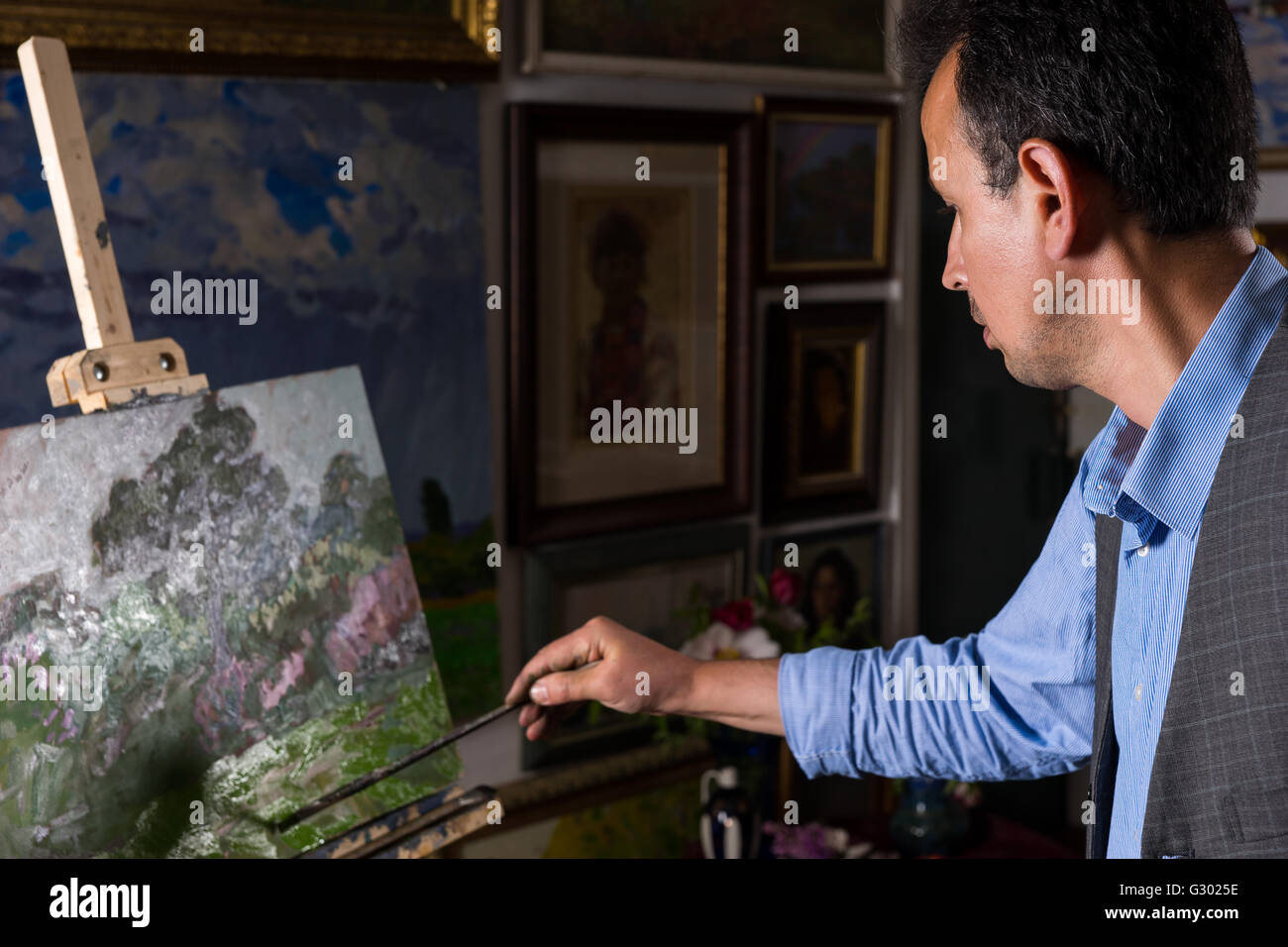 Contemplative male painter ending his masterpiece of a garden scene ...