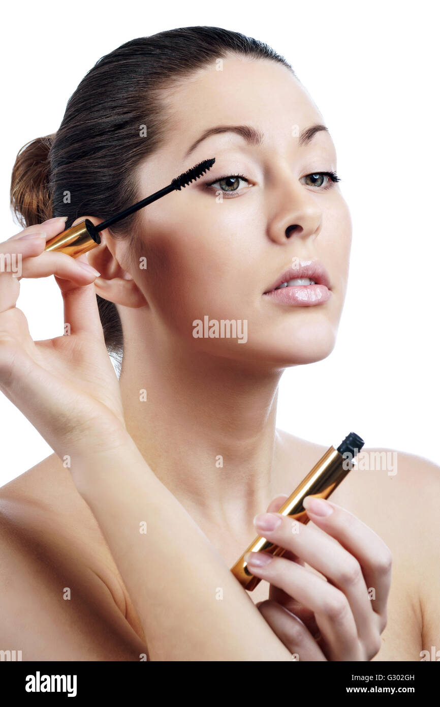 Beautiful young adult woman applying mascara on eyelashes Stock Photo ...