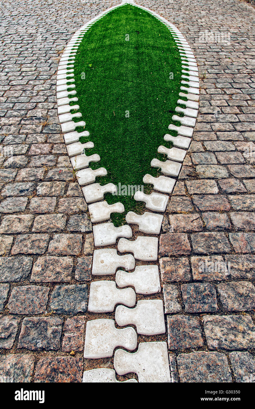 Artistic sidewalk zip reveals green grass for an environmental concept ...