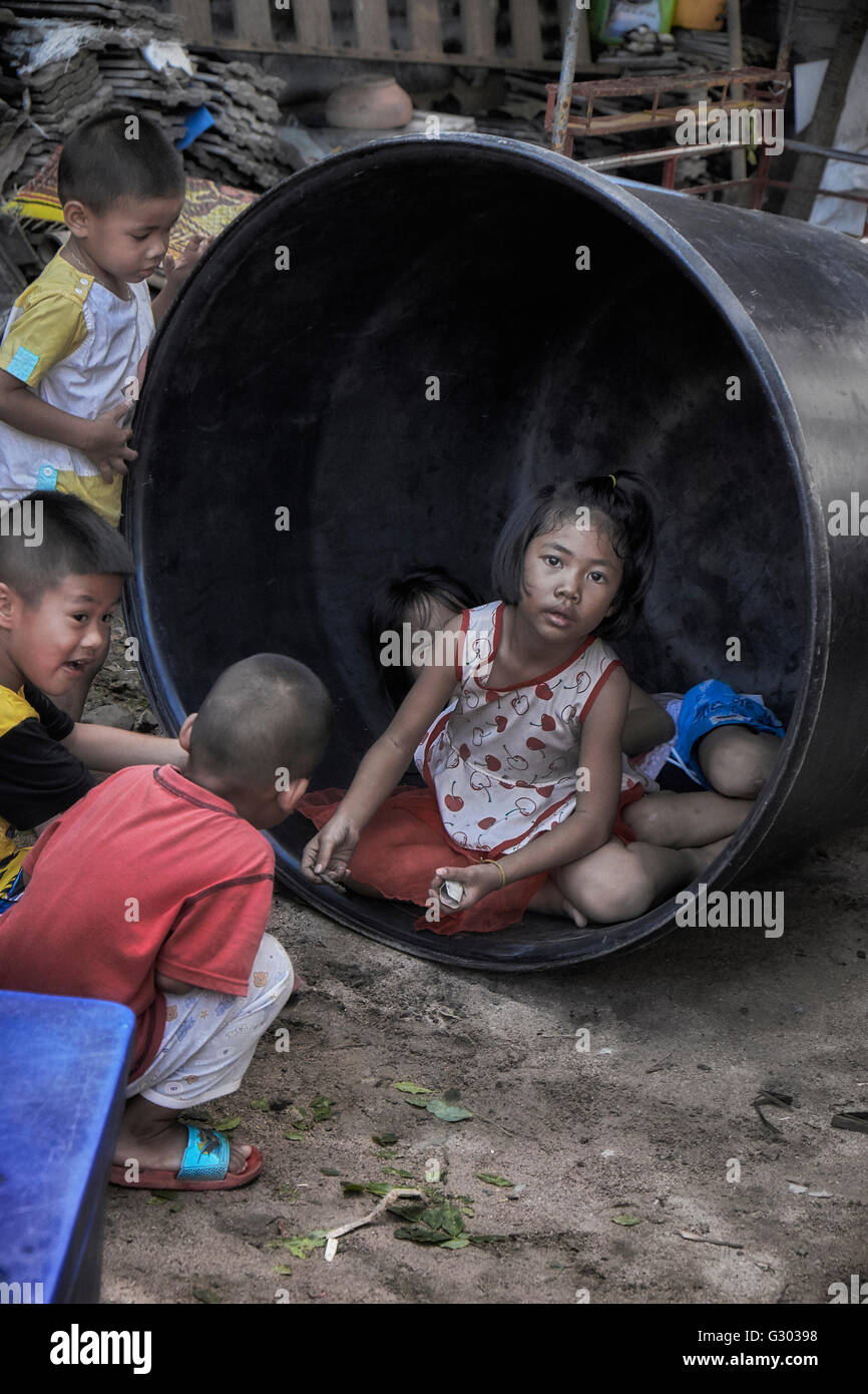 Thailand poverty. Children playing amongst the rubble in a Thai ...