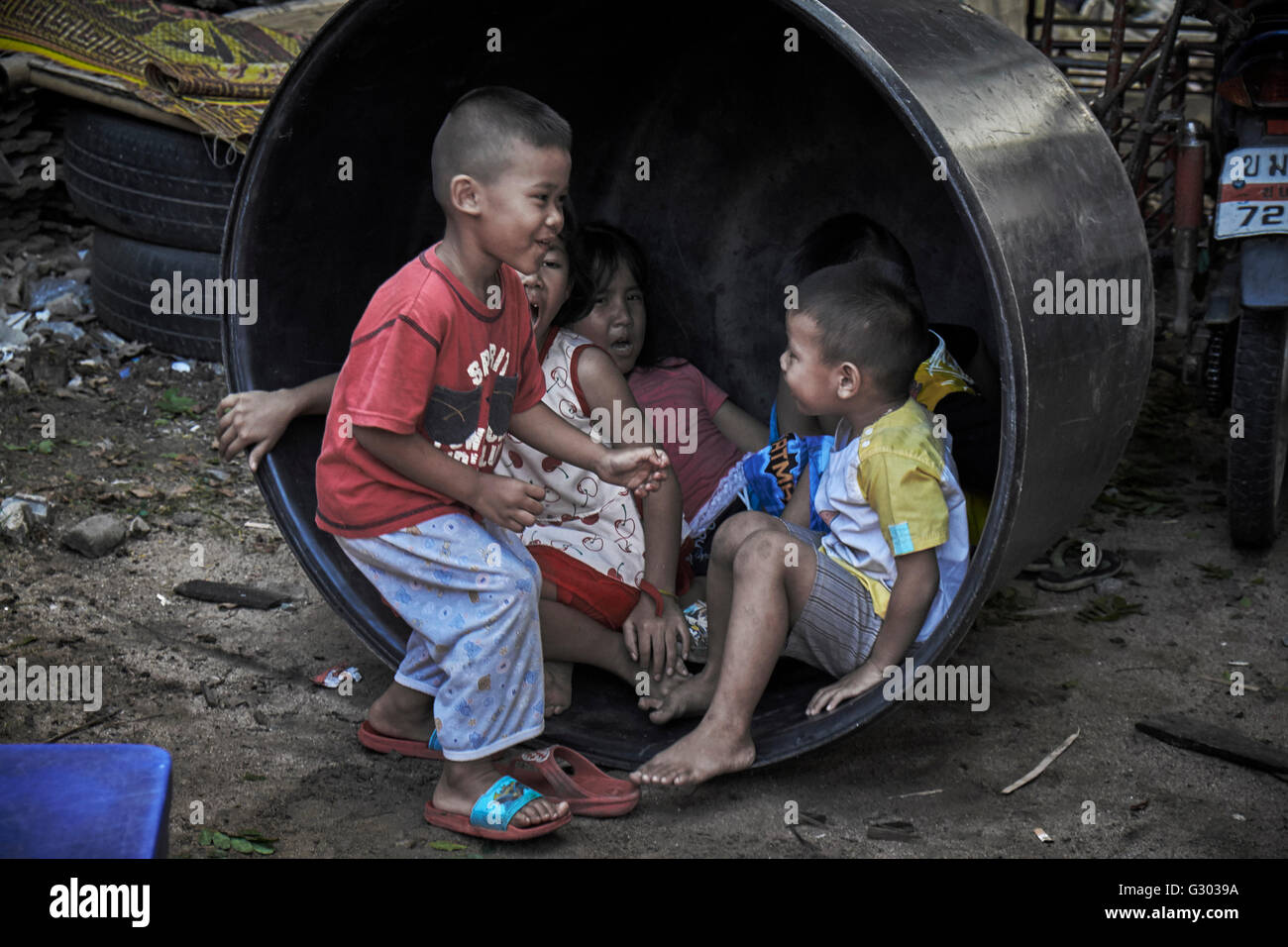Thailand poverty. Children playing amongst the rubble in a Thai ...