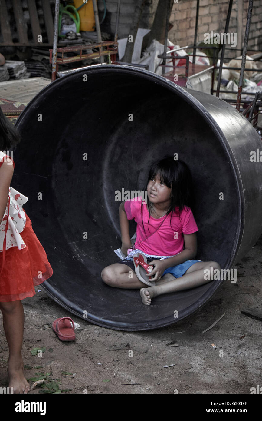 Thailand poverty. Children playing amongst the rubble in a Thai ...