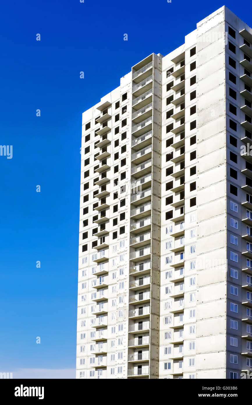 High-rise residental building under construction. On blue sky ...