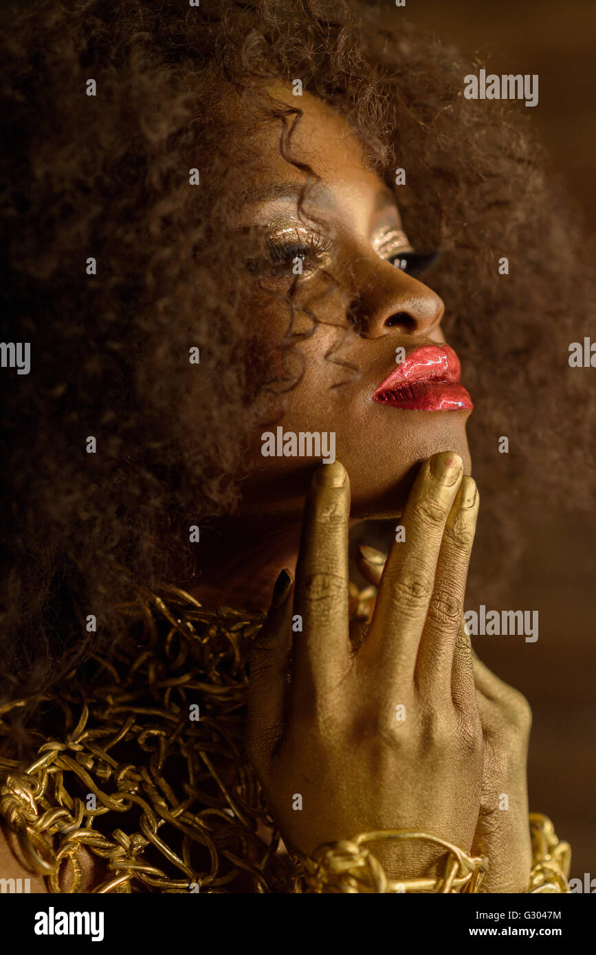 Elegant serious African or black American woman wearing gold makeup and ...