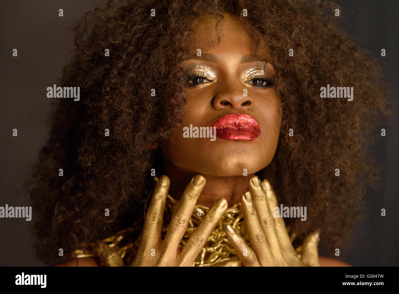 Elegant serious African or black American woman wearing gold makeup and ...