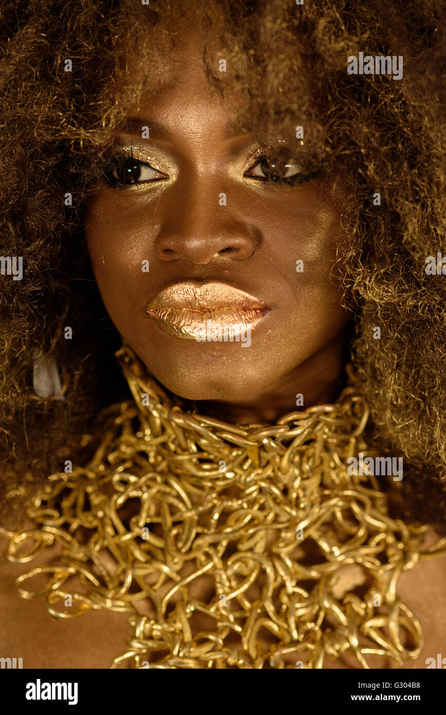 Beautiful dark model with golden jewelry and makeup. Fashion and beauty ...