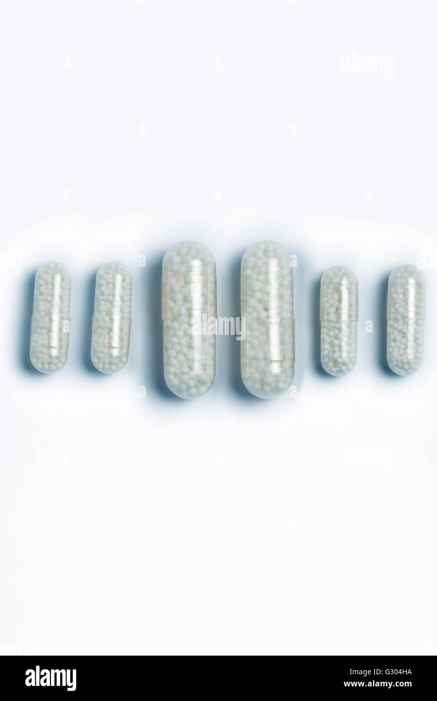 White capsules against a white background Stock Photo - Alamy