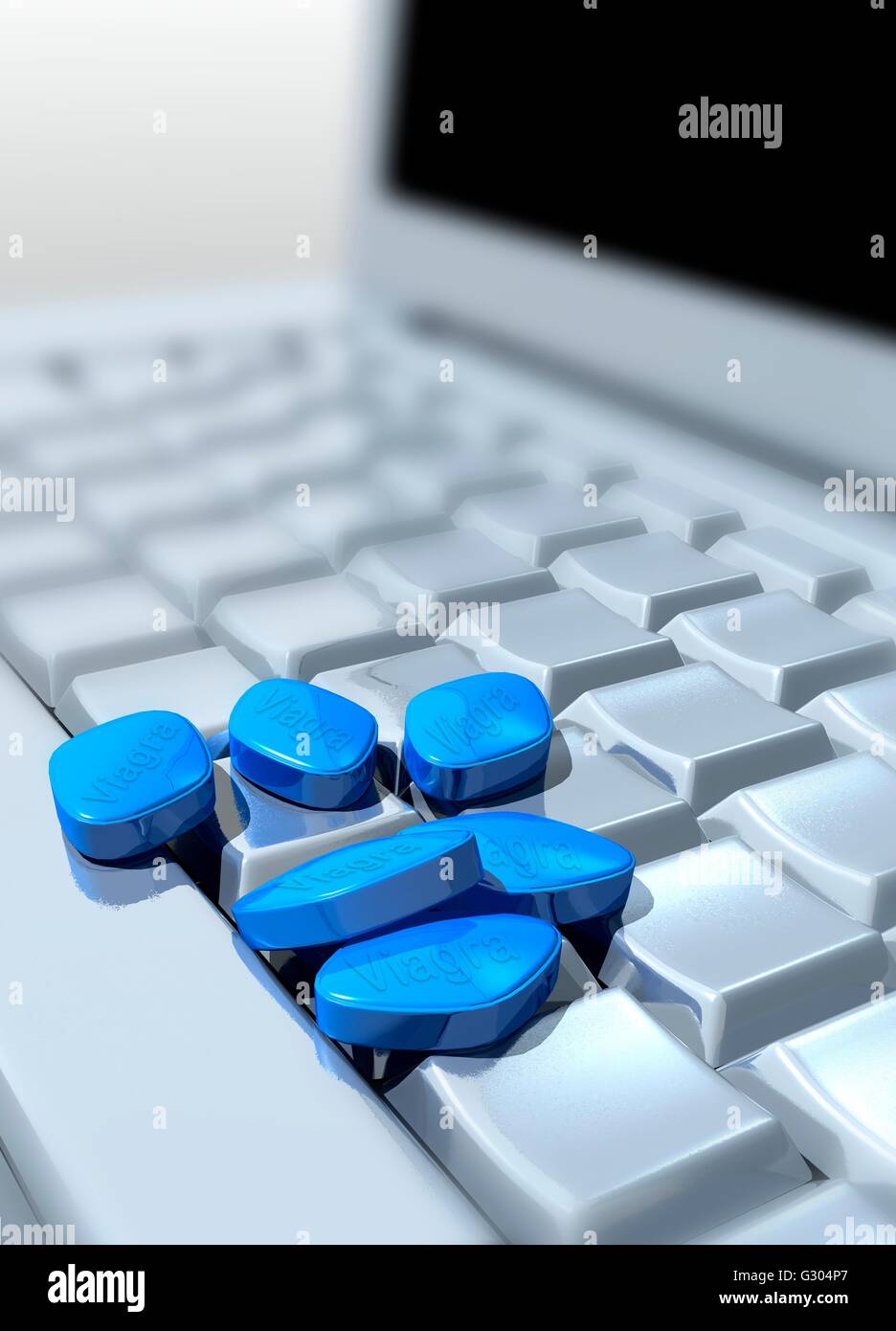 Blue pills on computer keyboard Stock Photo - Alamy