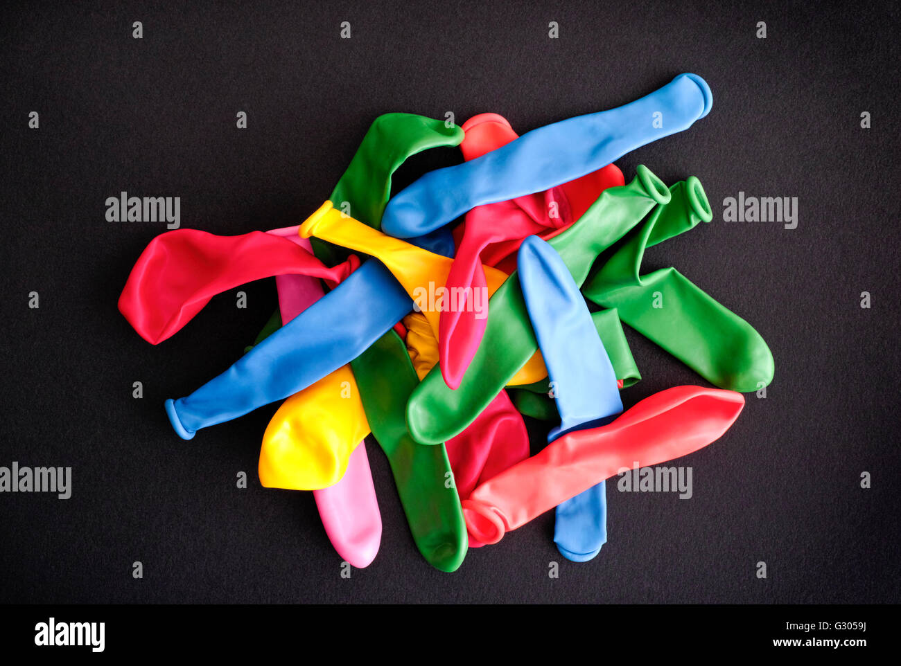 Pile of colorful uninflated balloons on black background Stock Photo ...